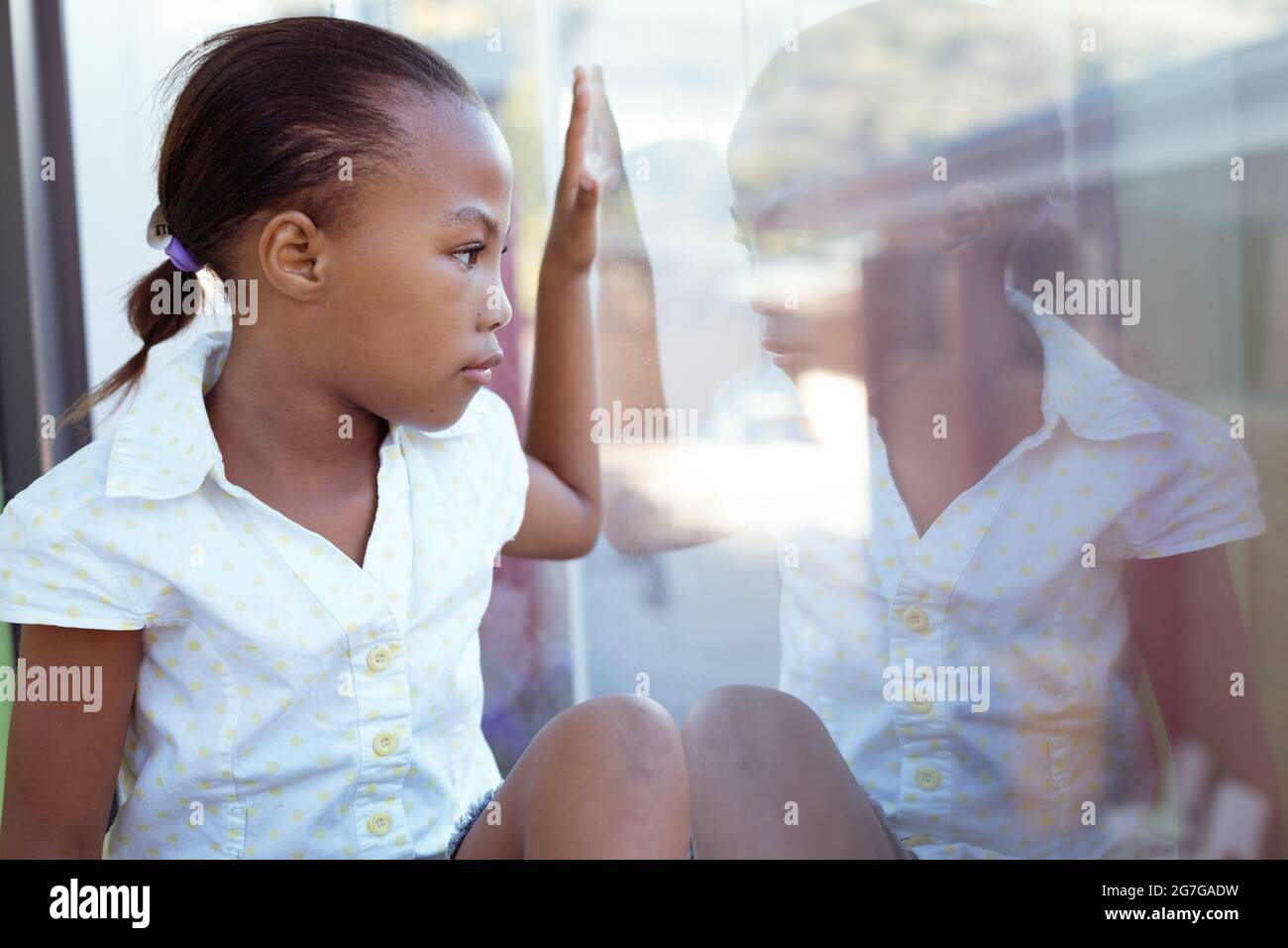 Une écolière afro-américaine assise dans une salle de classe et ... Une écolière afro-américaine assise dans une salle de classe et ...