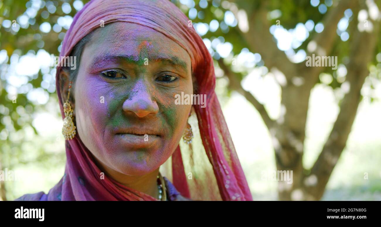 Gros plan d'une femme indienne avec un visage coloré sur le festival de ...
