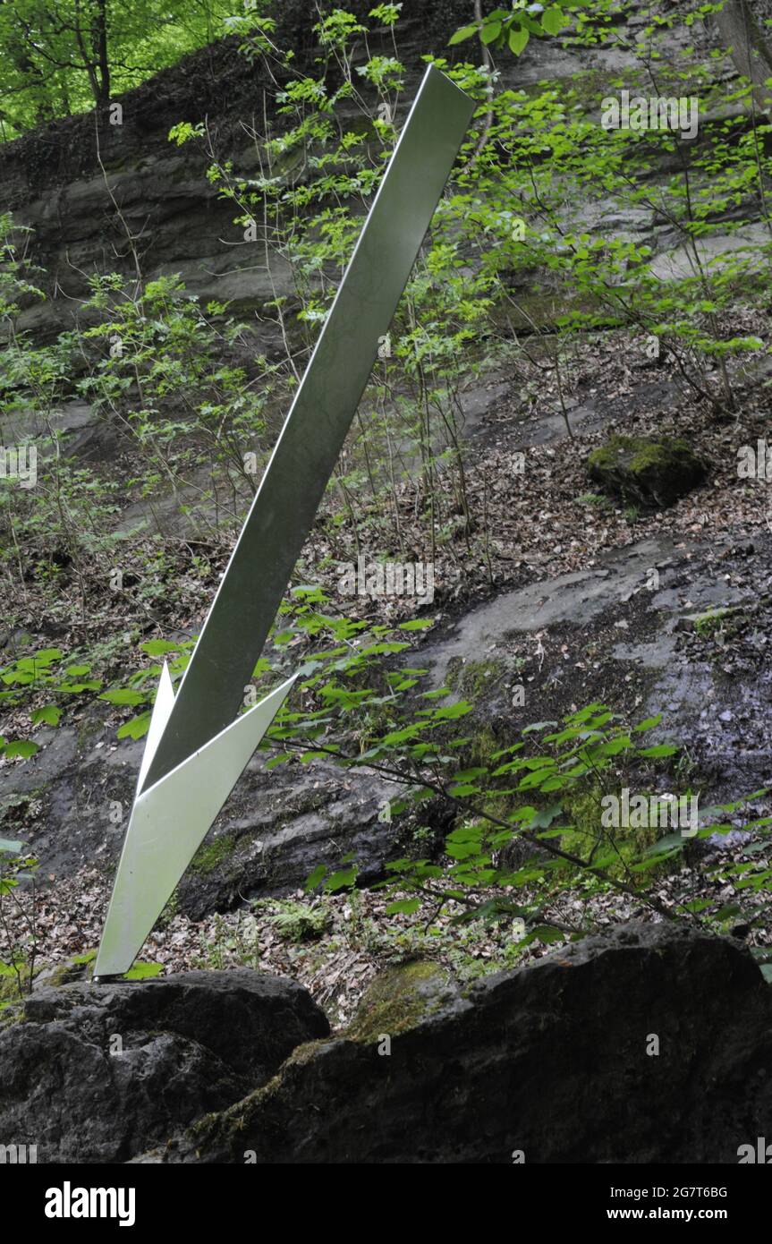 Plan vertical d'une flèche métallique coincée dans une roche au milieu ...