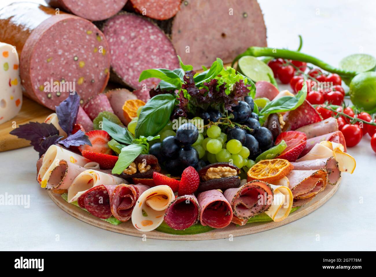 Assiette à viande sur fond de bois blanc. Ensemble de salami. Coupes ...