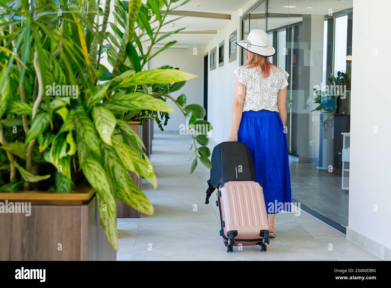 une fille a l'hôtel à visiter. Tourisme avec une valise marche le long ...