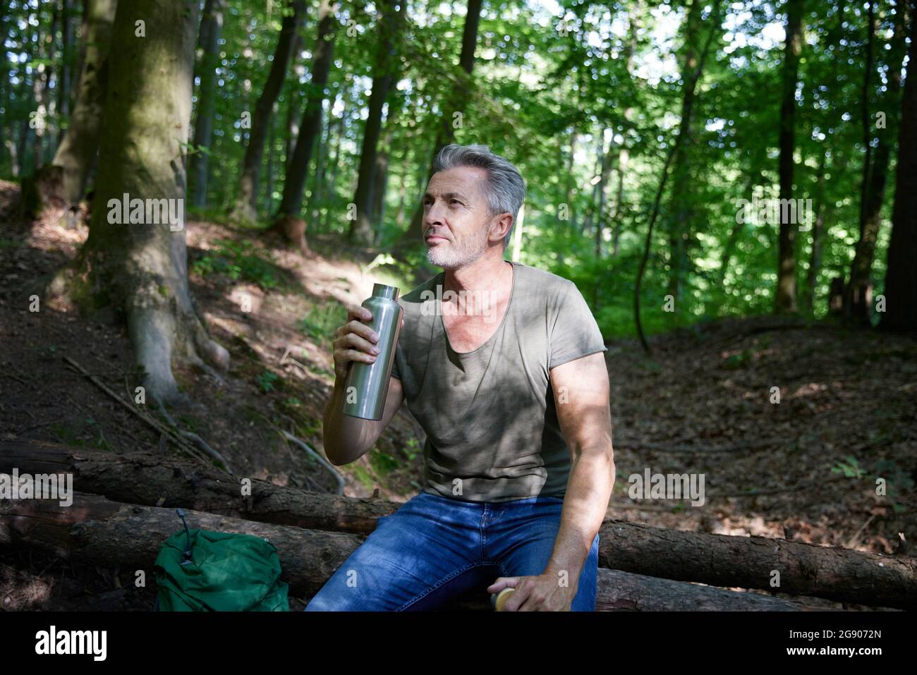 Homme assis sur un tronc d'arbre Banque de photographies et d’images à ...