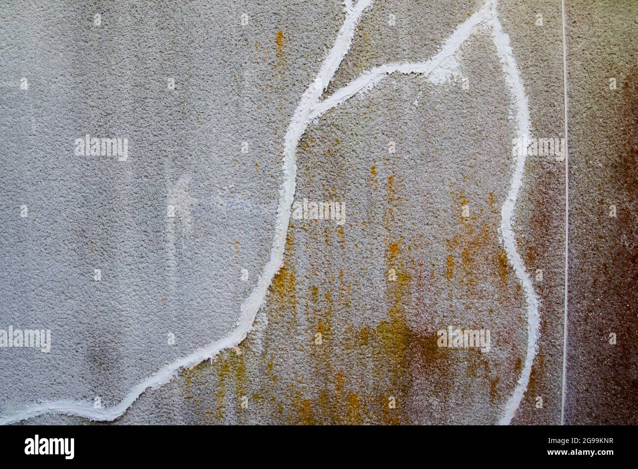 Mur de béton avec courant le long des fissures réparées avec du mastic ...