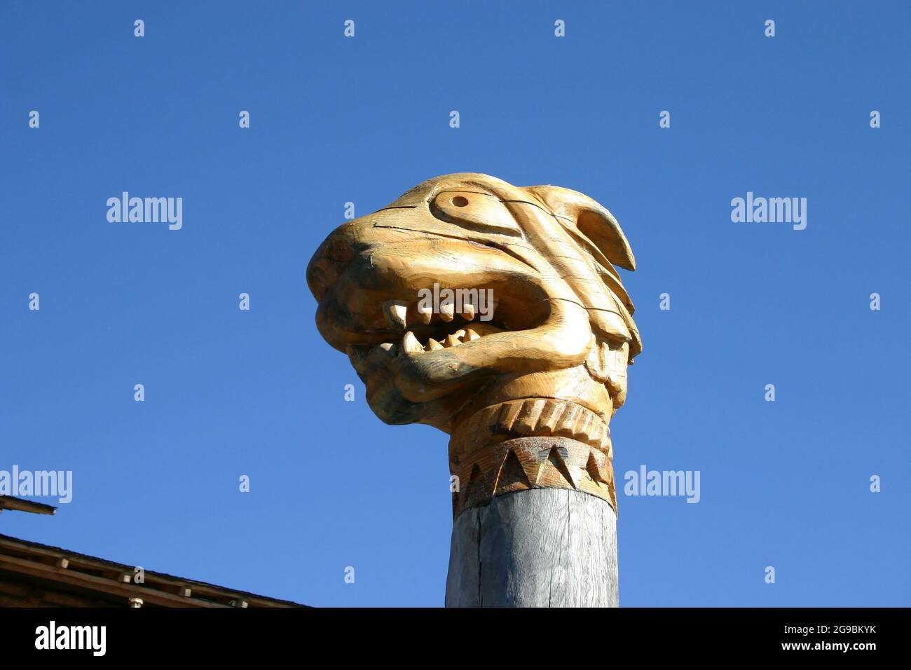 Coupe à la main d'un totem en bois, tête d'un dragon mythique sur la ...