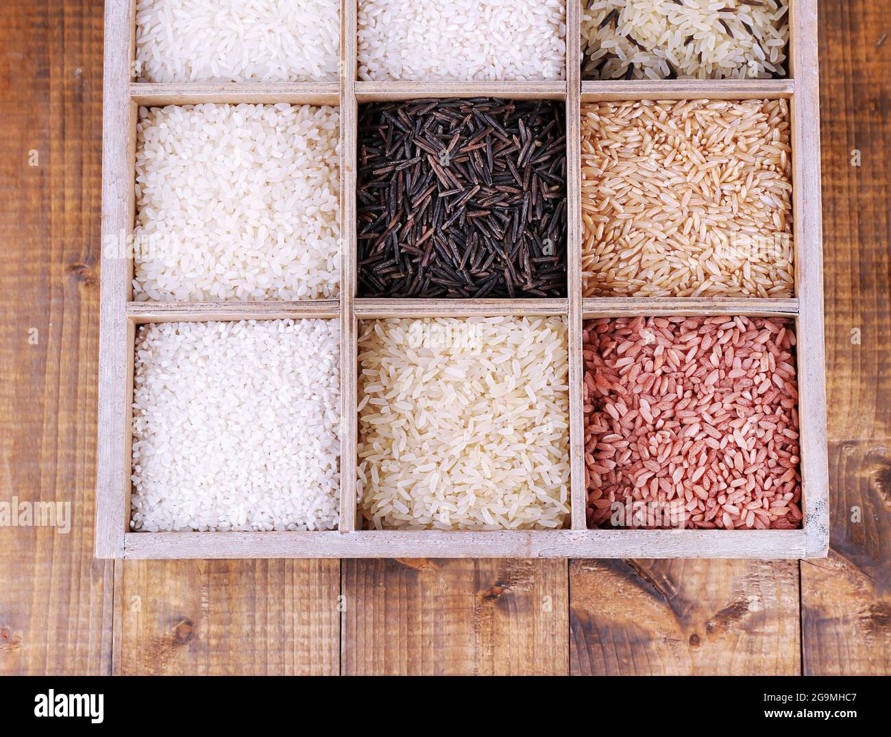Différents types de riz en boîte sur fond de bois Photo Stock - Alamy