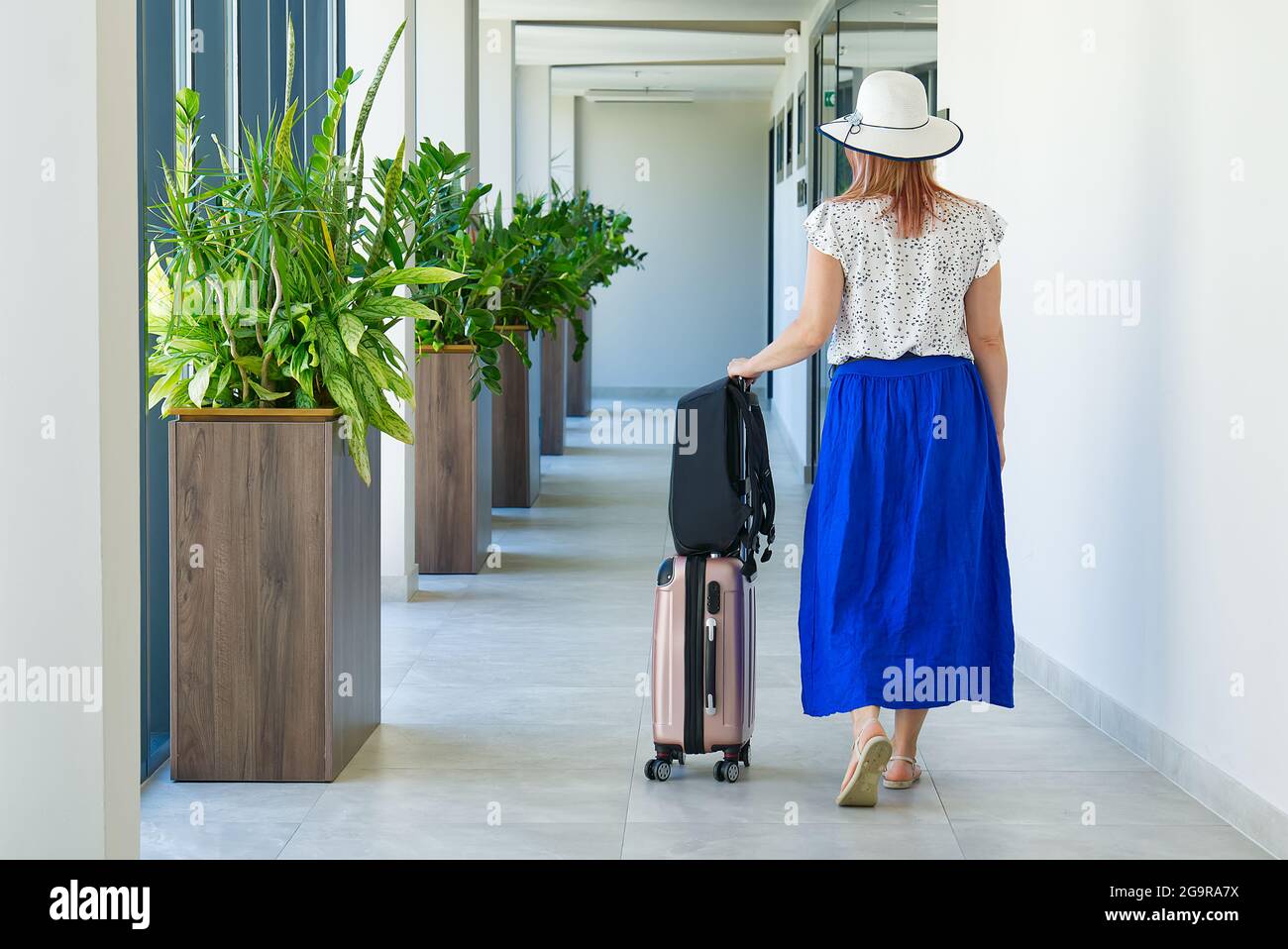 une fille a l'hôtel à visiter. Tourisme avec une valise marche le long ...