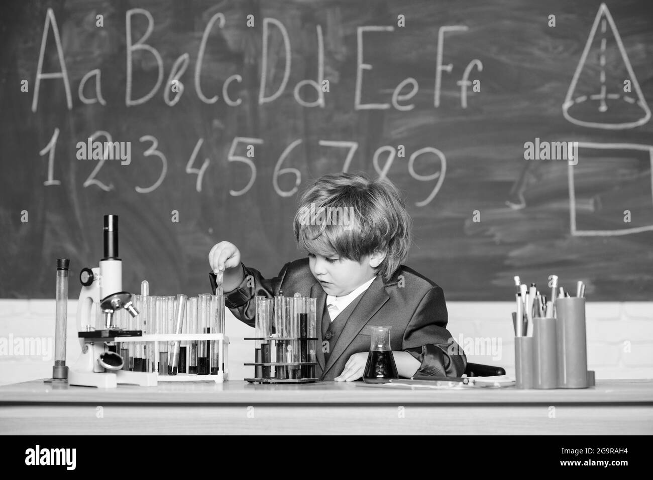 petit garçon utilisant le microscope à la leçon d'école. petit garçon ...