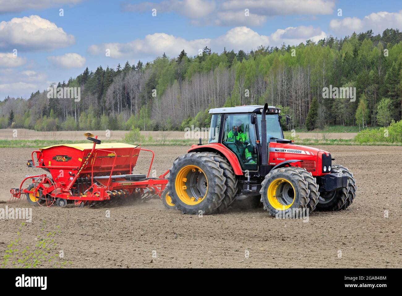 Tracteur avec semoir travaillant dans un champ au printemps Banque de ...