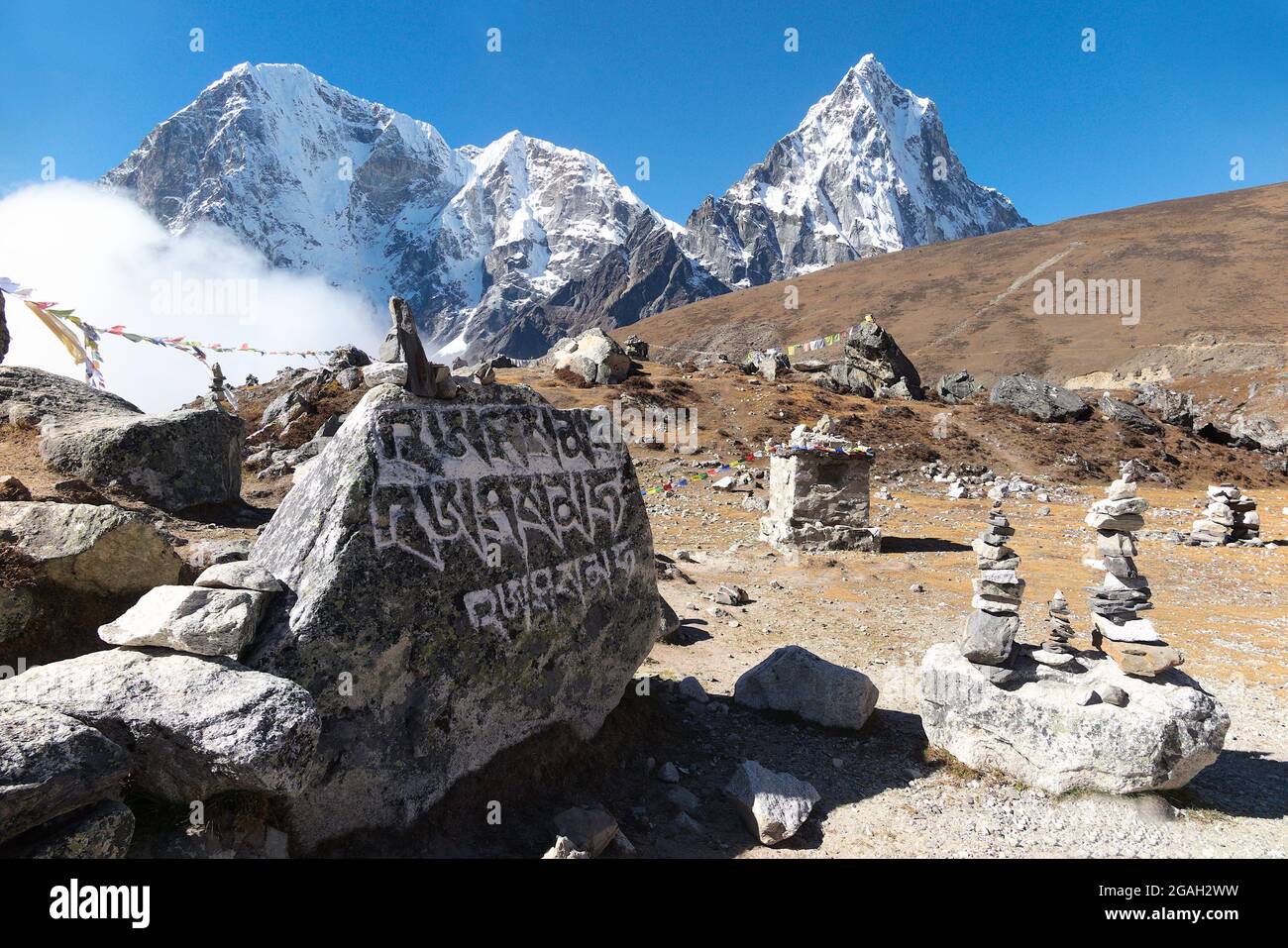 Pierre tibétaine de cairns, drapeaux de prière et roche avec mantra ...