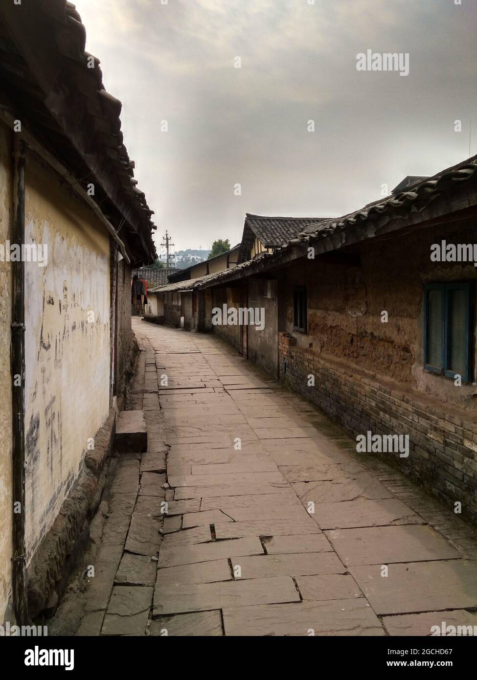 Une ancienne allée avec une route en pierre de galets et de vieux murs ...