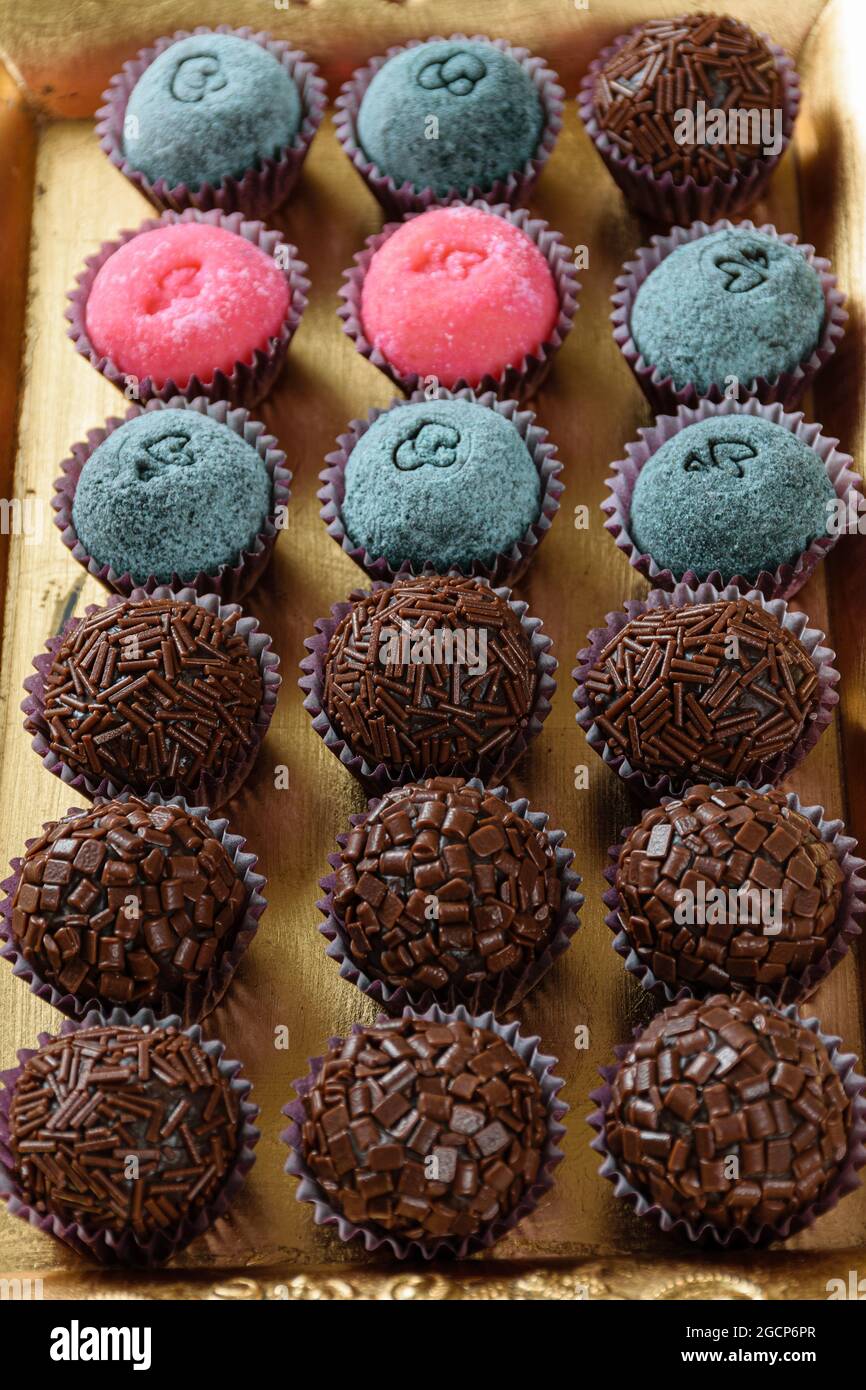 Gros plan de différents types de brigadeiro sur un plateau doré sucré ...
