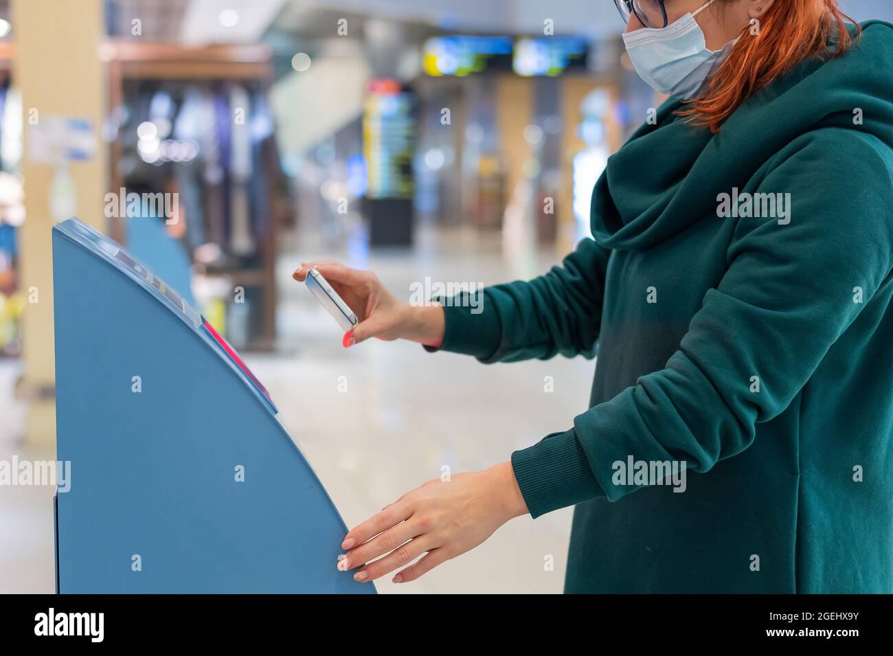 Une femme dans un masque scanne le code qr depuis son smartphone. Une ...