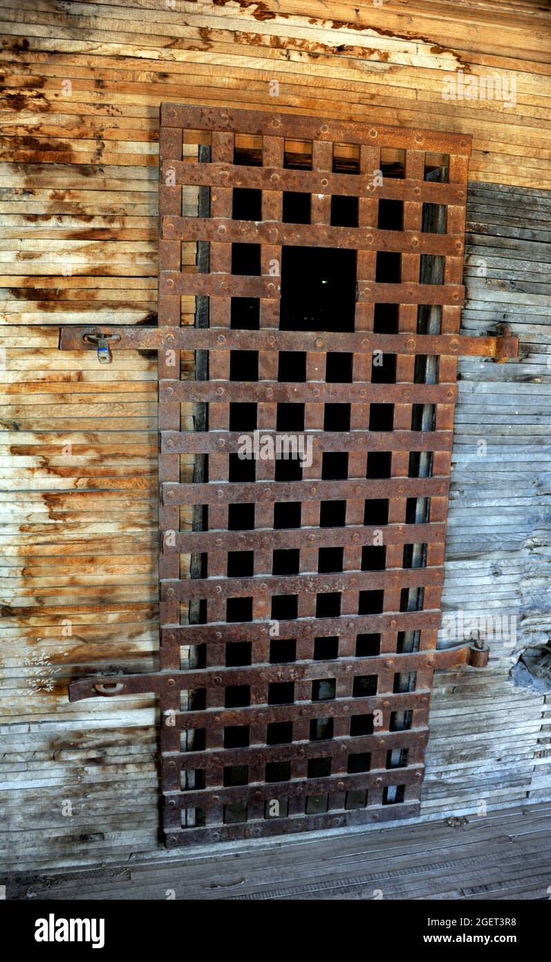 La porte de prison barrée est rustique avec une ouverture entre les ...