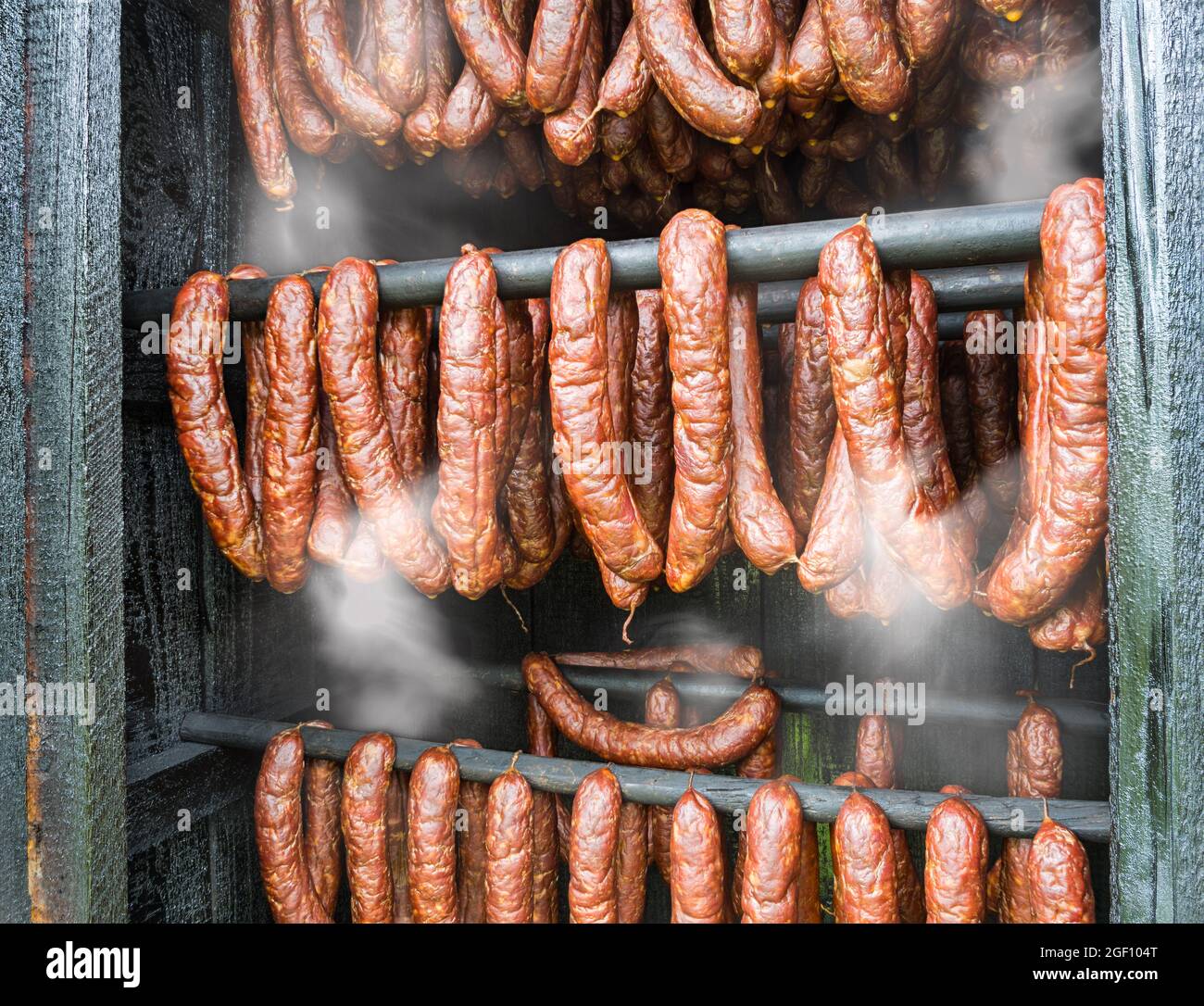 Fumage de kielbasa salamis épicé dans un détail de maison de fumée en ...