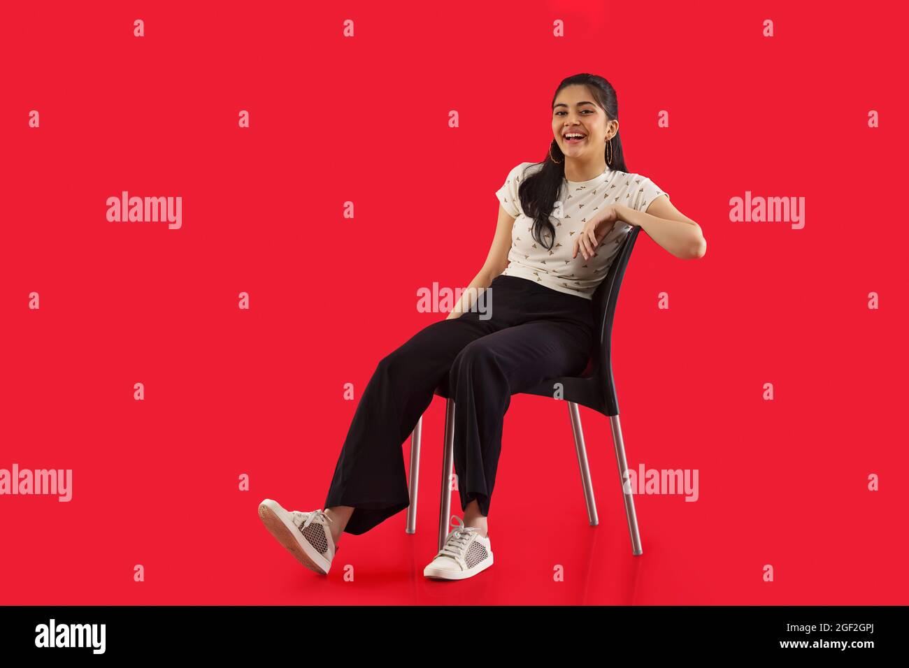 Jeune femme assise sur une chaise Banque de photographies et d’images à haute résolution - Alamy