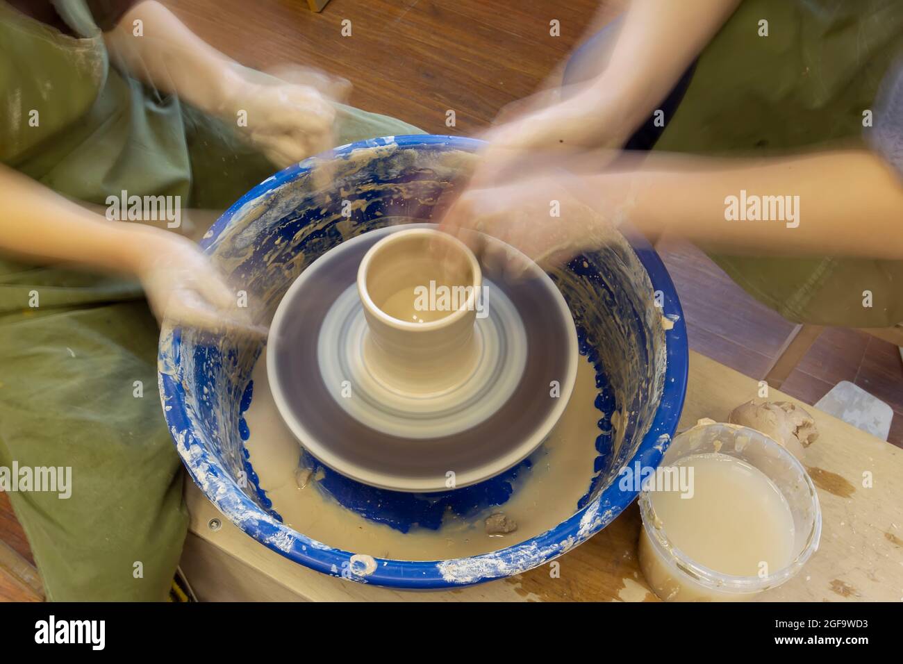 Faïence sur une roue de potier et les mains d'un potier, flou en ...