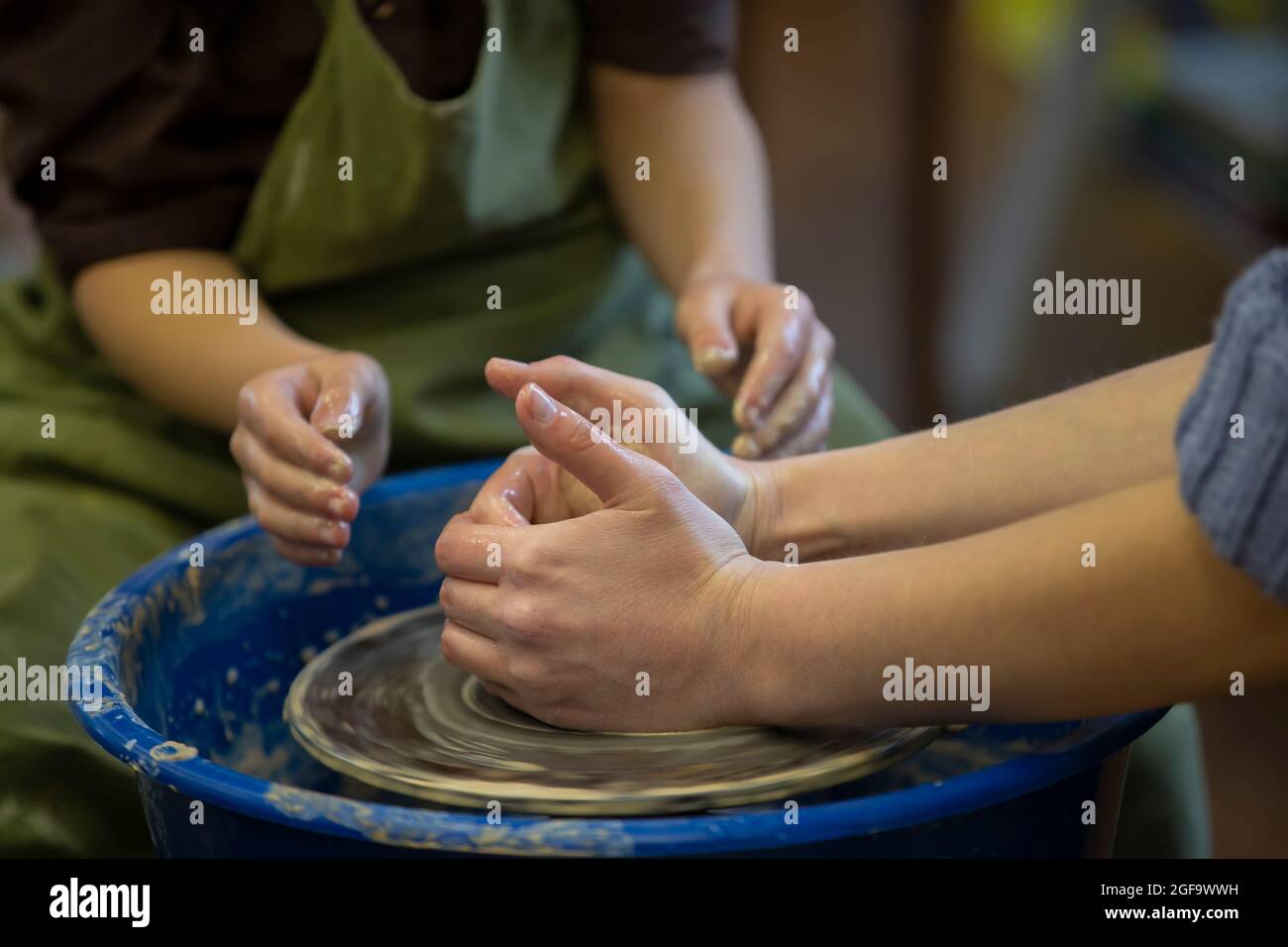 Le potier enseigne l'artisanat à l'enfant. Gros plan des mains d'un ...