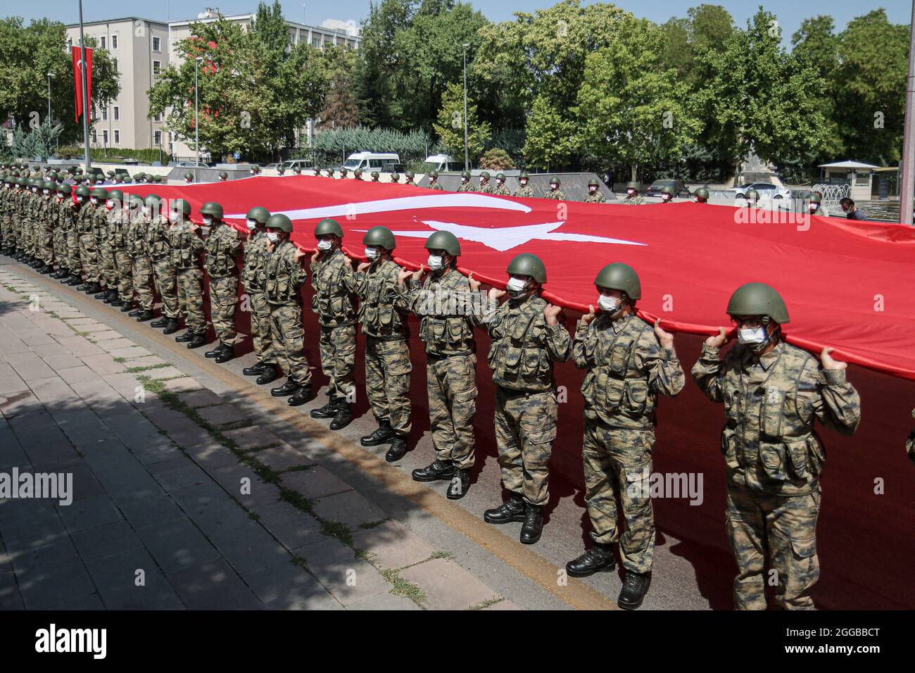 Les soldats turcs marchent avec un drapeau turc pendant le défilé ...