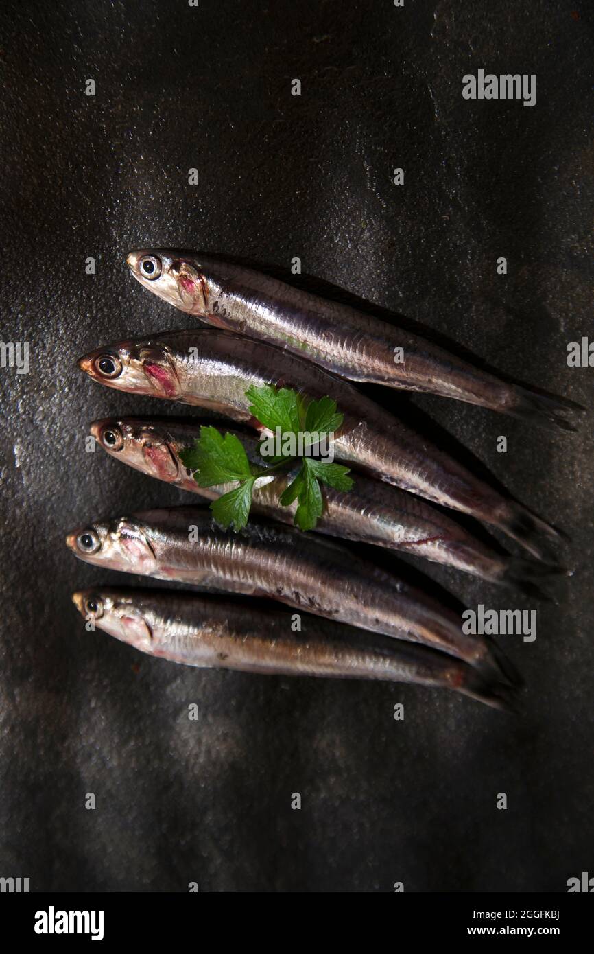 Présentation de la série anchois brut au-dessus de fond pierre noire ...