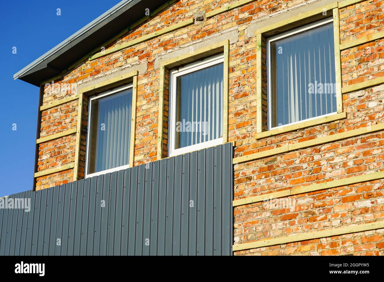 bardage de façade de maison en brique rouge avec tôle ondulée Photo ...
