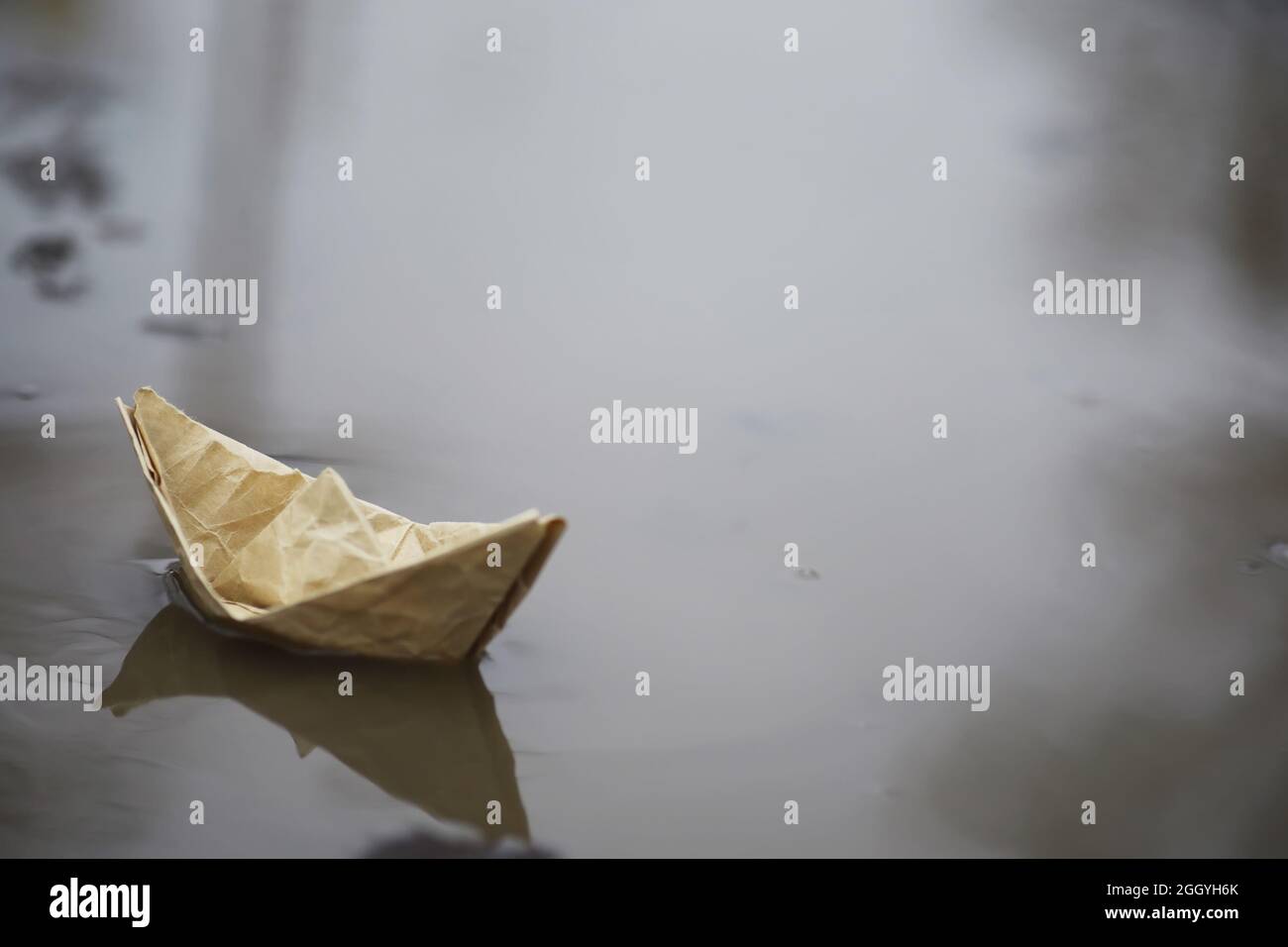 Bateau en papier dans l'eau sur la rue. Le concept au début du ...
