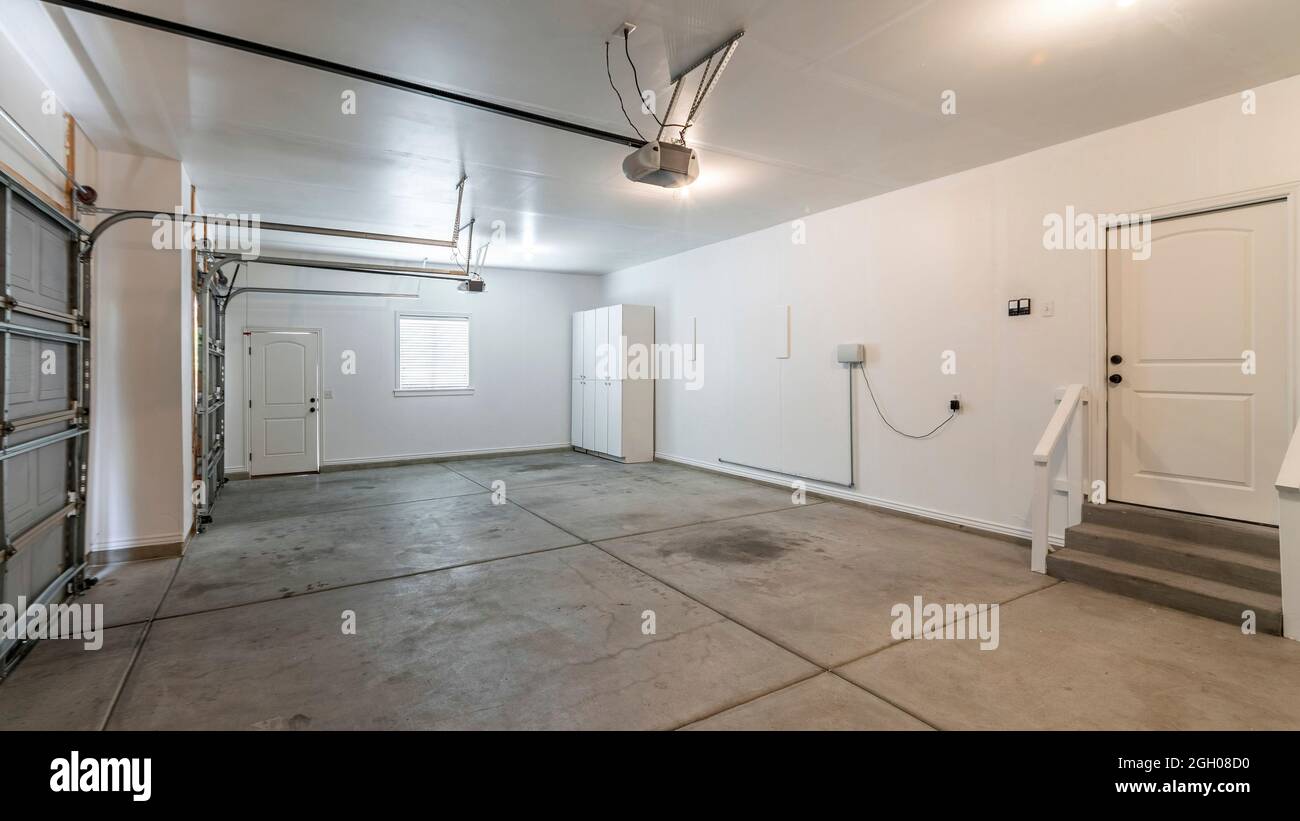 Pano intérieur d'un garage avec deux portes automatiques et plancher en ...