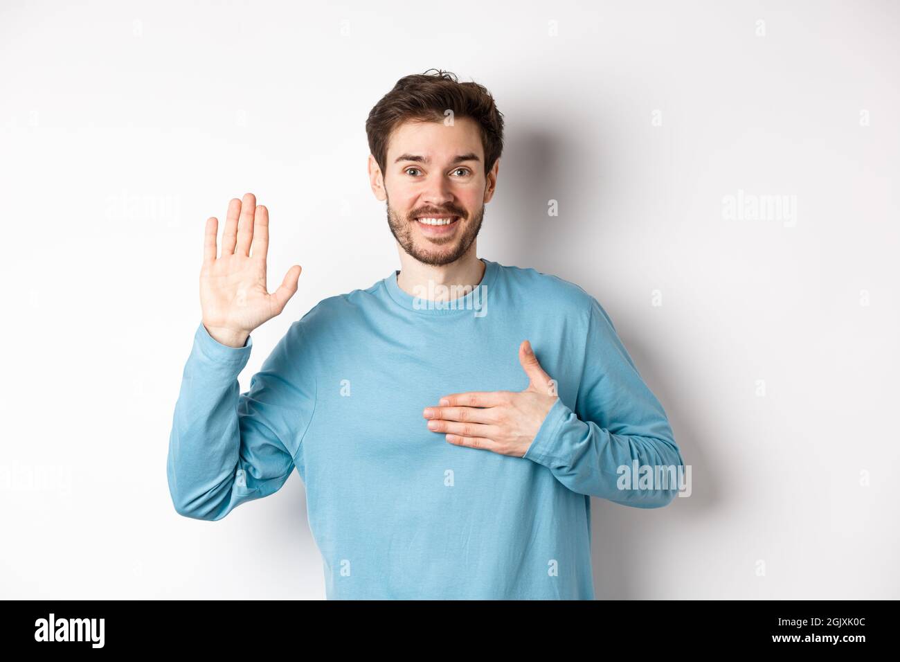 Homme souriant qui se soulève le bras et tient la main sur le coeur ...