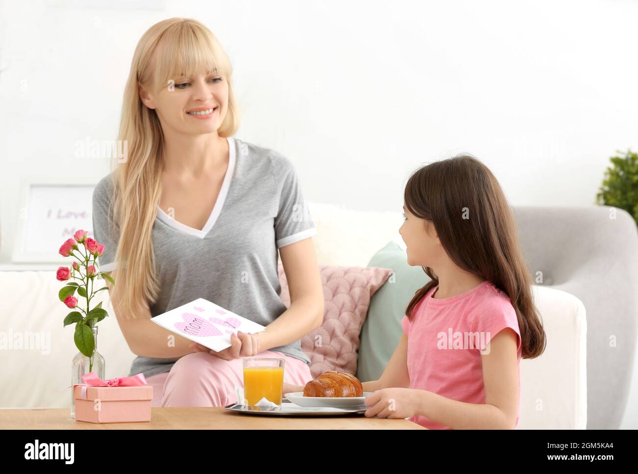 Petite fille préparer le petit-déjeuner, de cadeaux et de fleurs pour ...