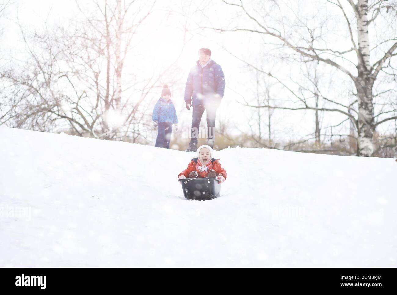 Enfants dans le parc en hiver. Les enfants jouent avec la neige sur l ...