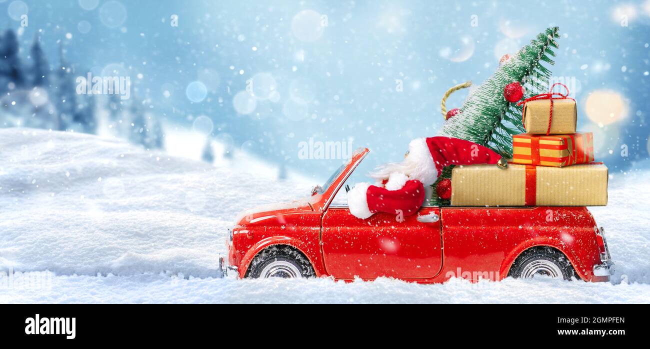 Le Père Noël en voiture rouge livre l'arbre de noël et présente sur ...