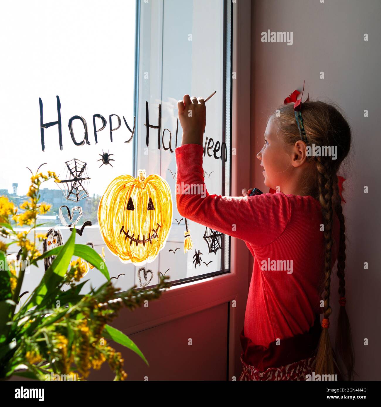 Enfants dans les cornes de diable peindre la citrouille sur la fenêtre ...