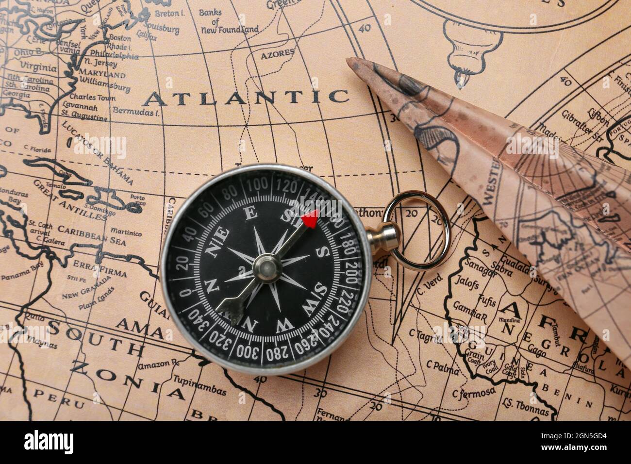 Ancienne boussole et avion en papier sur la carte du monde d'époque ...