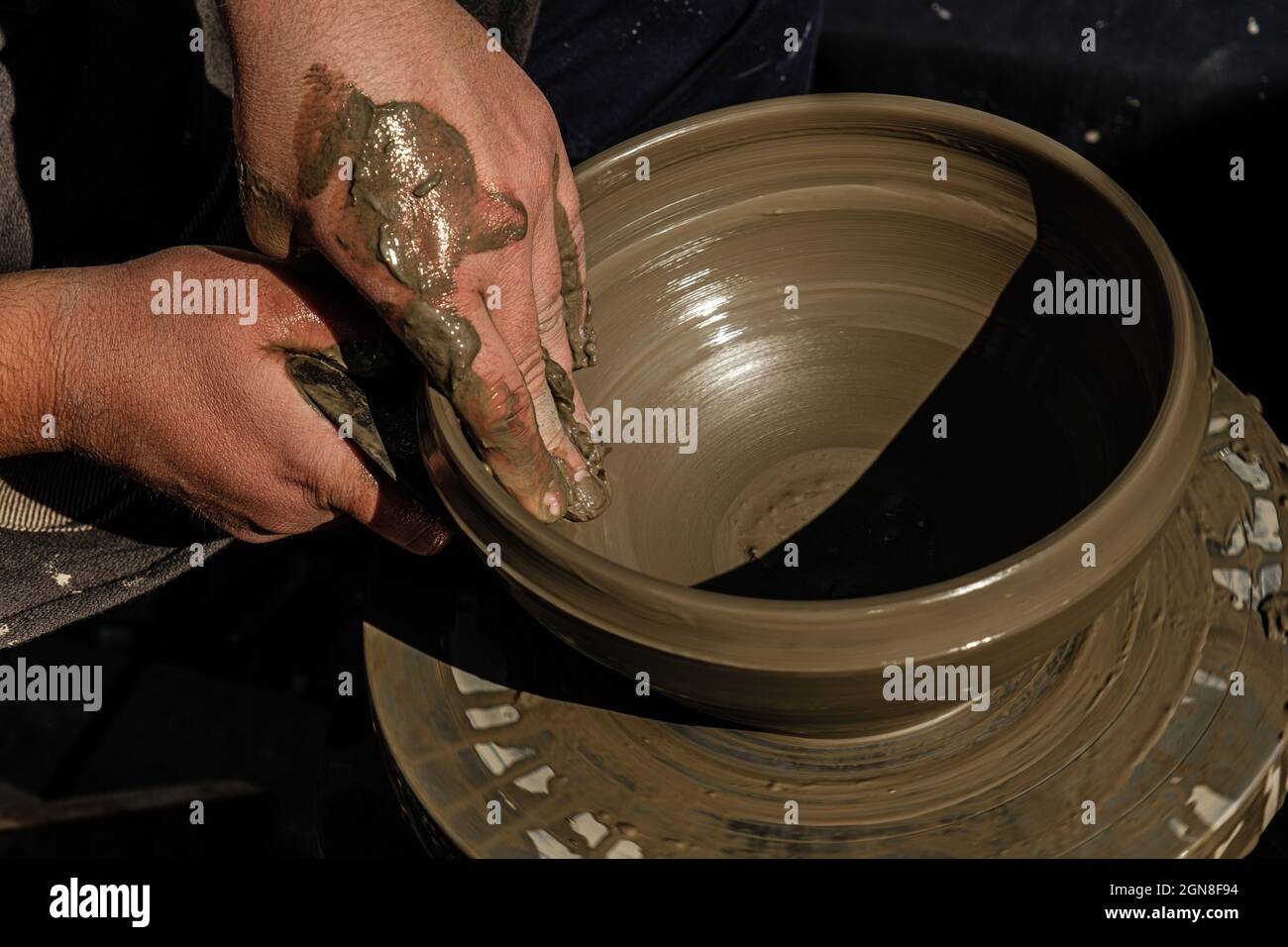 Mains d'un potier façonnant un pot d'argile sur un roue de potier Photo ...