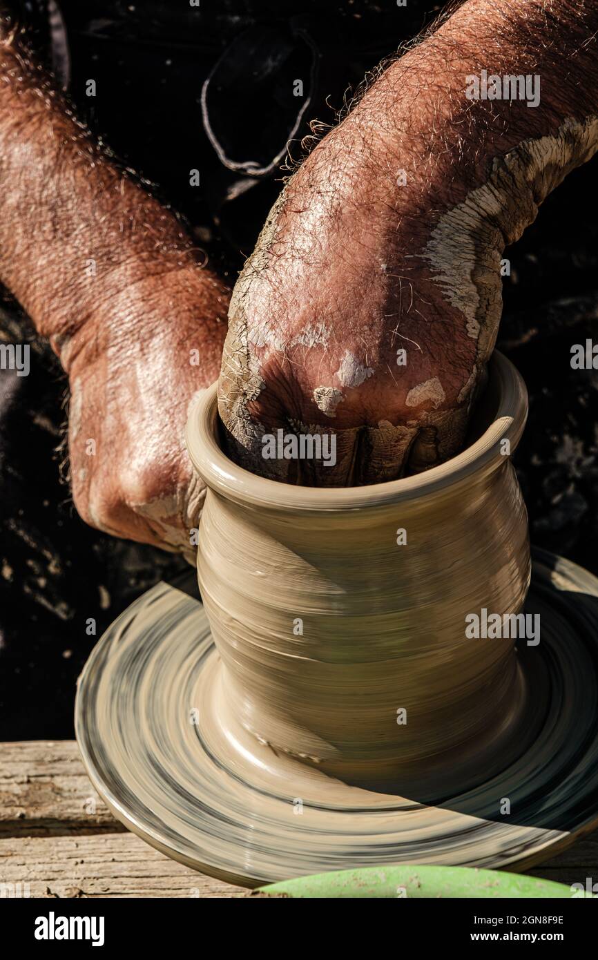Mains d'un potier façonnant un pot d'argile sur un roue de potier Photo ...