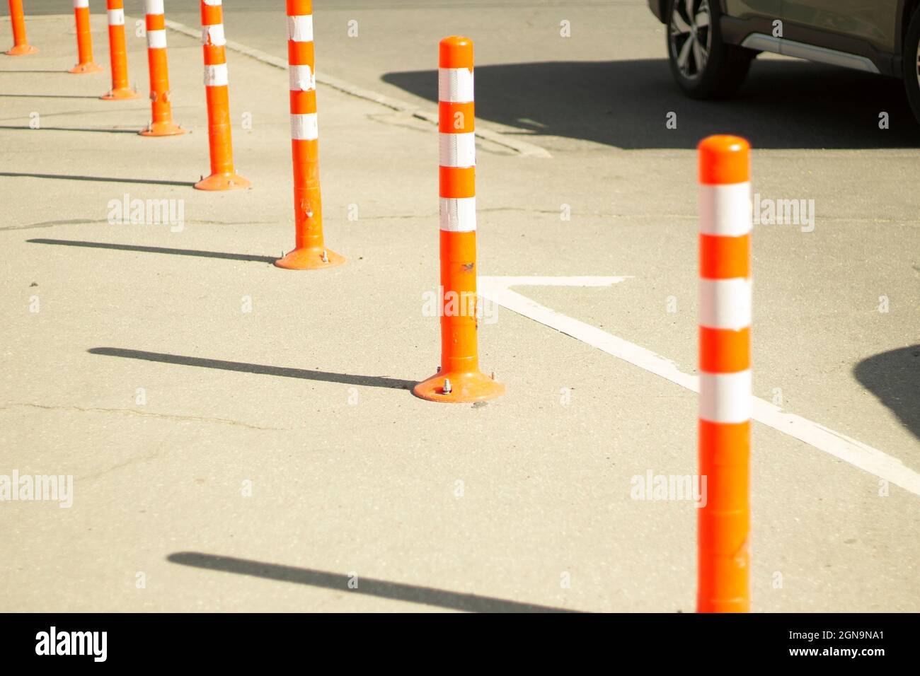 Arrêts de stationnement. Poteaux orange dans le parking. Clôtures de ...