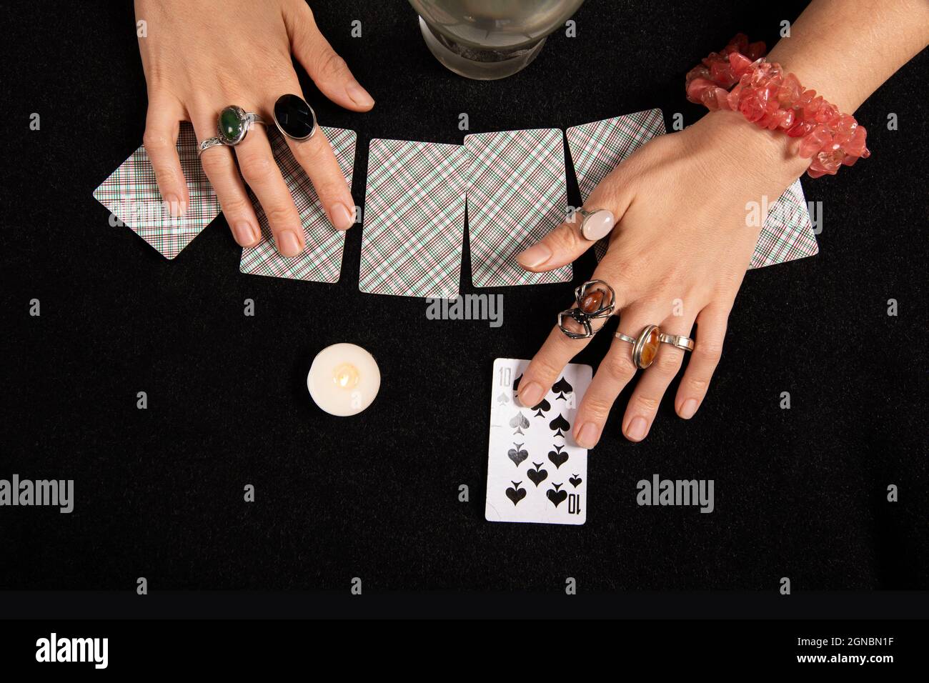 Des mains de tueur de fortune ou de sorcière, des cartes, des bougies ...