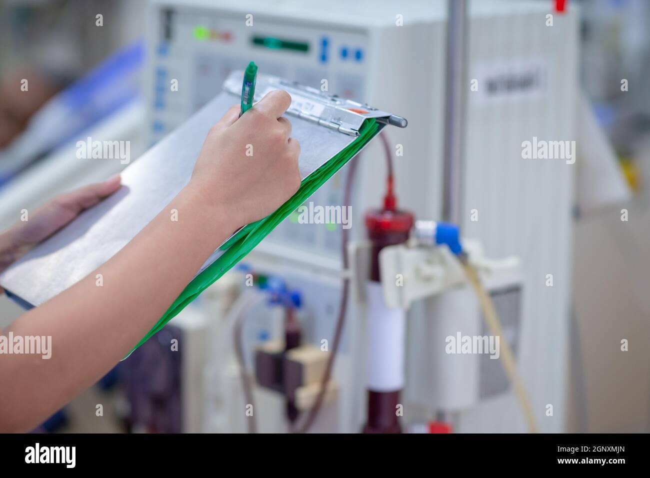 L'infirmière en dialyse vérifie l'appareil de dialyse avant de procéder ...