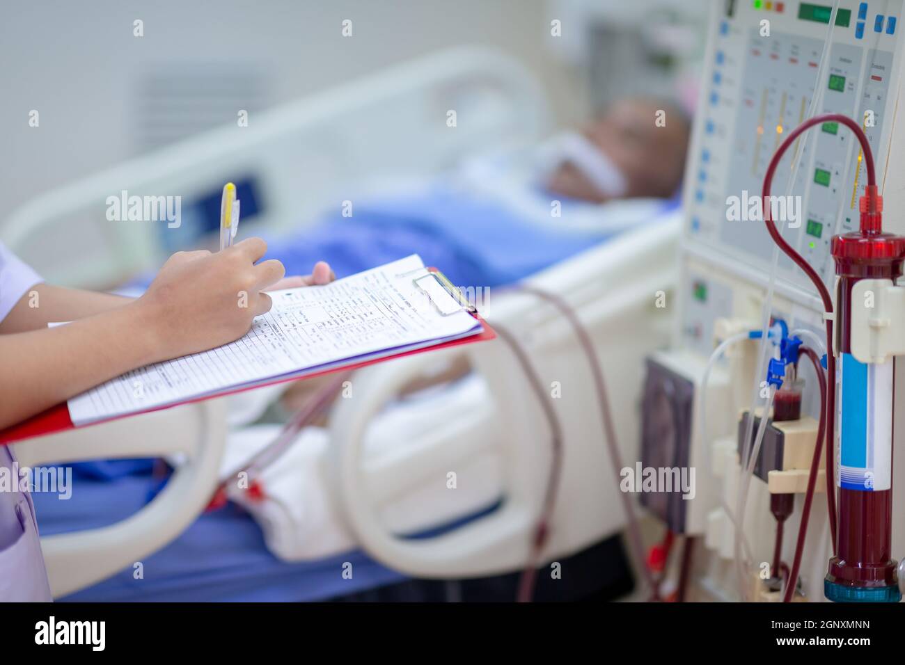 L'infirmière en dialyse vérifie l'appareil de dialyse avant de procéder ...