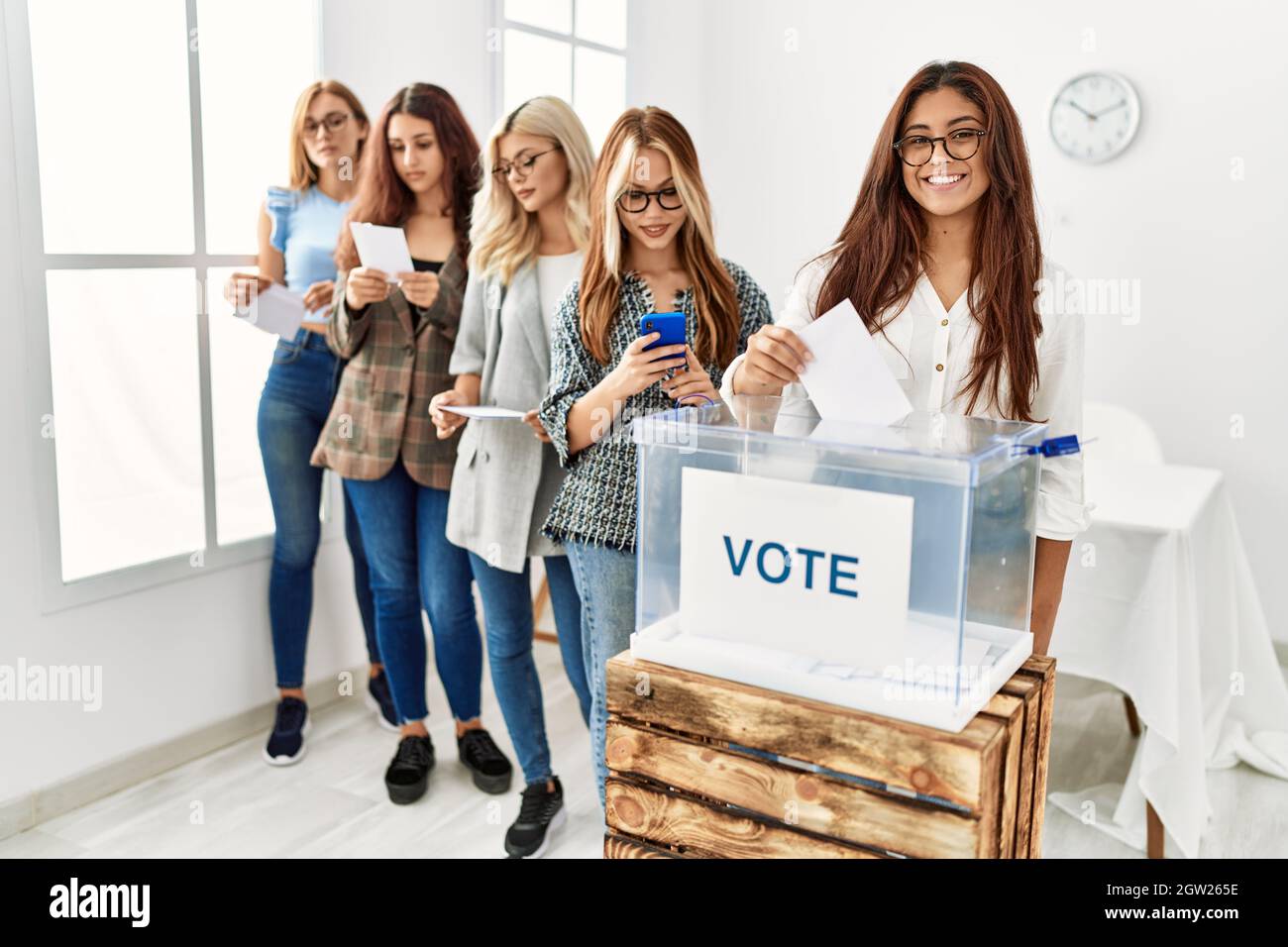 Groupe de jeunes électrices souriantes, heureux de mettre le vote dans ...