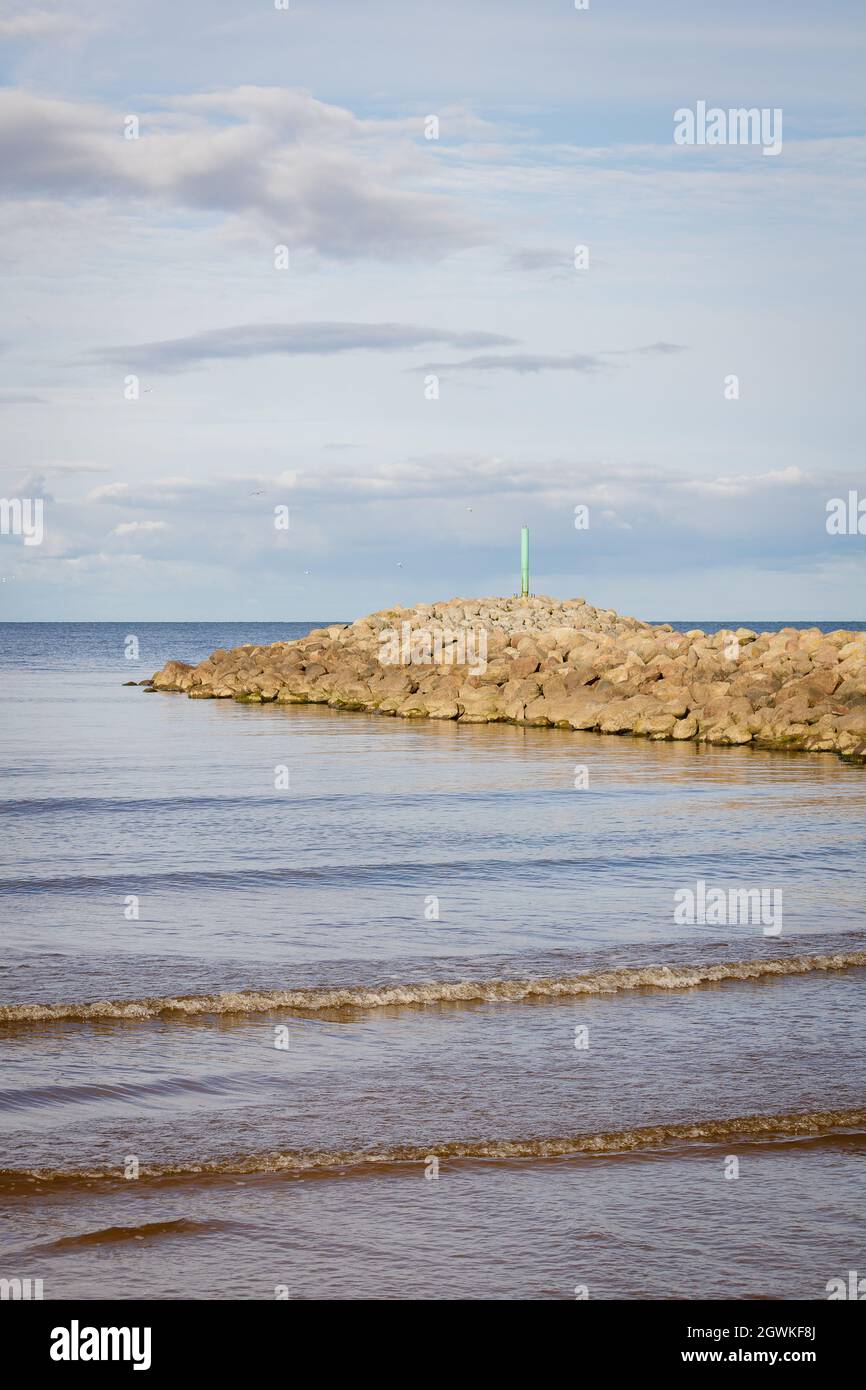 Des pierres sèches et immenses dans la mer ont séché au soleil. Un quai ...