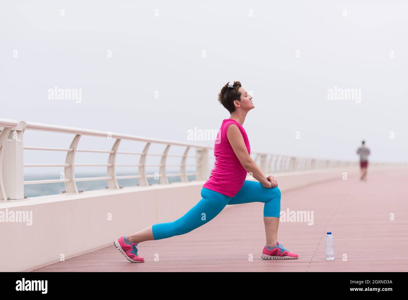 Très jeune belle femme qui s'étend et se réchauffer sur la promenade le long du bord de l'océan ...