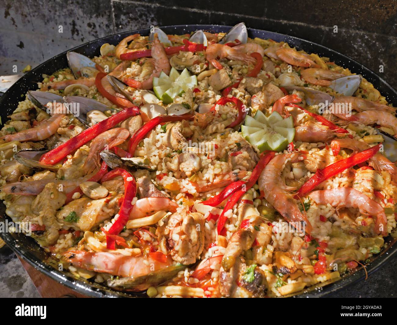 Une grande paella fraîche traditionnelle avec de la viande et des ...