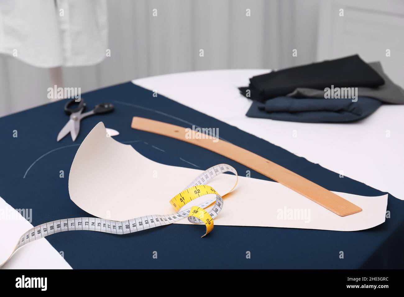 Règle, mètre ruban, gabarit en papier et tissu sur table dans un ...