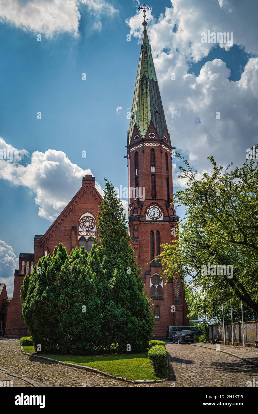 Belle église en brique rouge avec une tour d'horloge, une paroisse ...