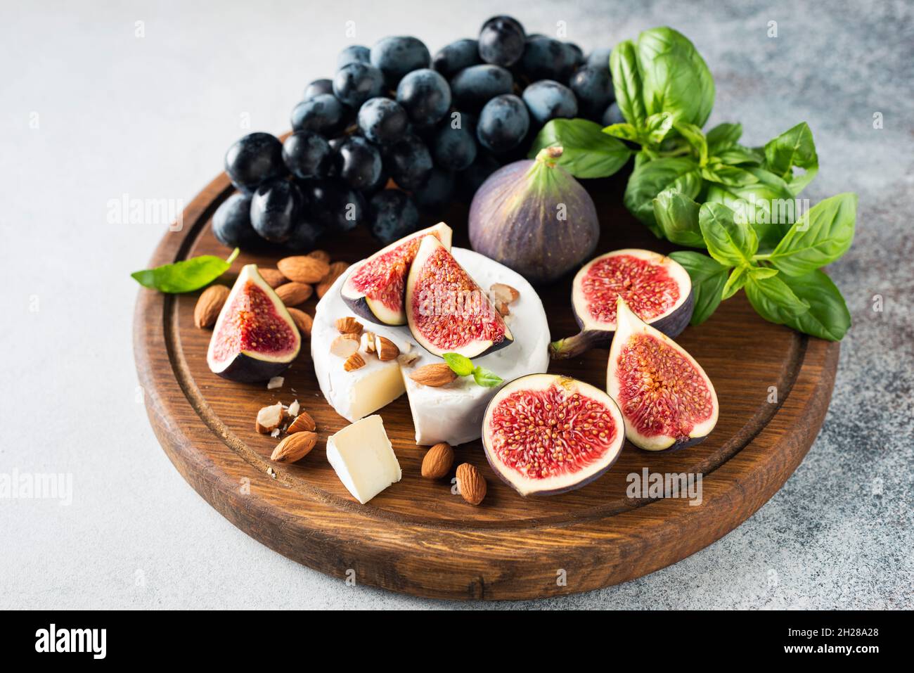 Plateau de fromages avec camembert, figues, raisins et noix.Assiette de ...