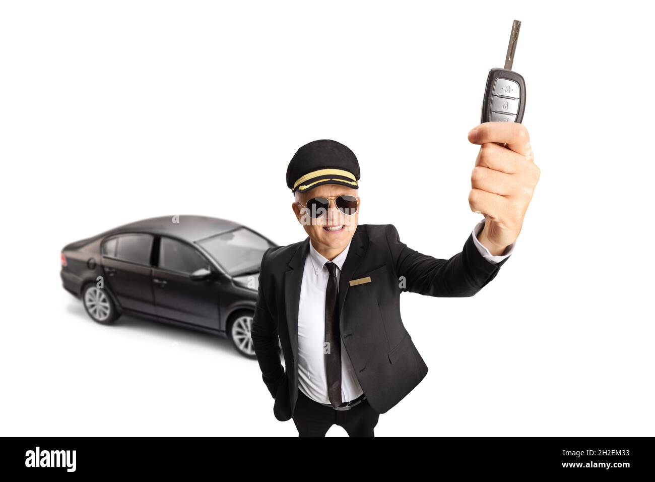Chauffeur professionnel dans un uniforme montrant une clé devant une ...