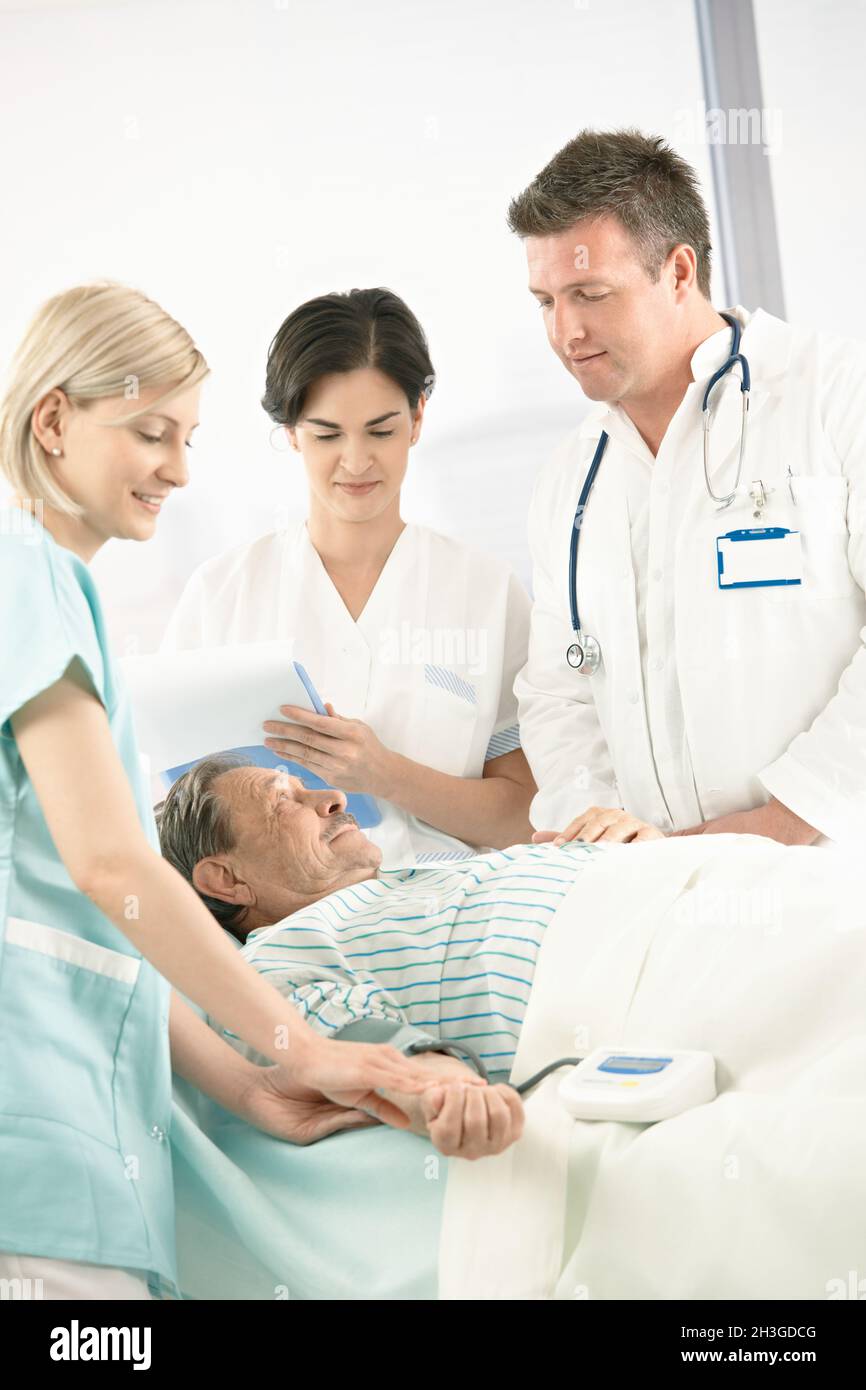 Médecins et infirmière avec un patient plus âgé Photo Stock - Alamy