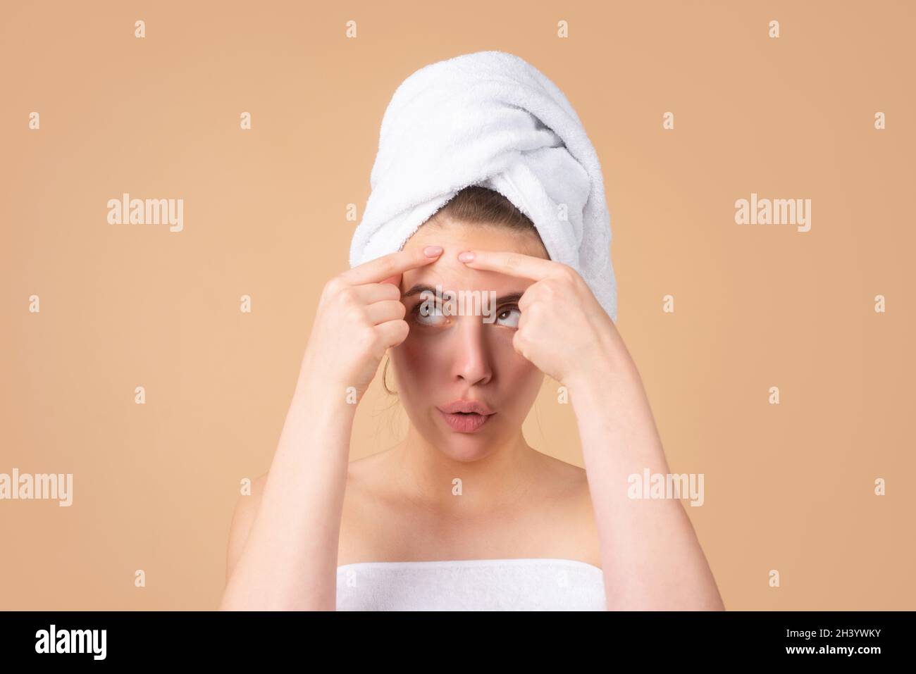 Belle fille pressant des boutons sur son visage.Taches de défaut d'acné ...