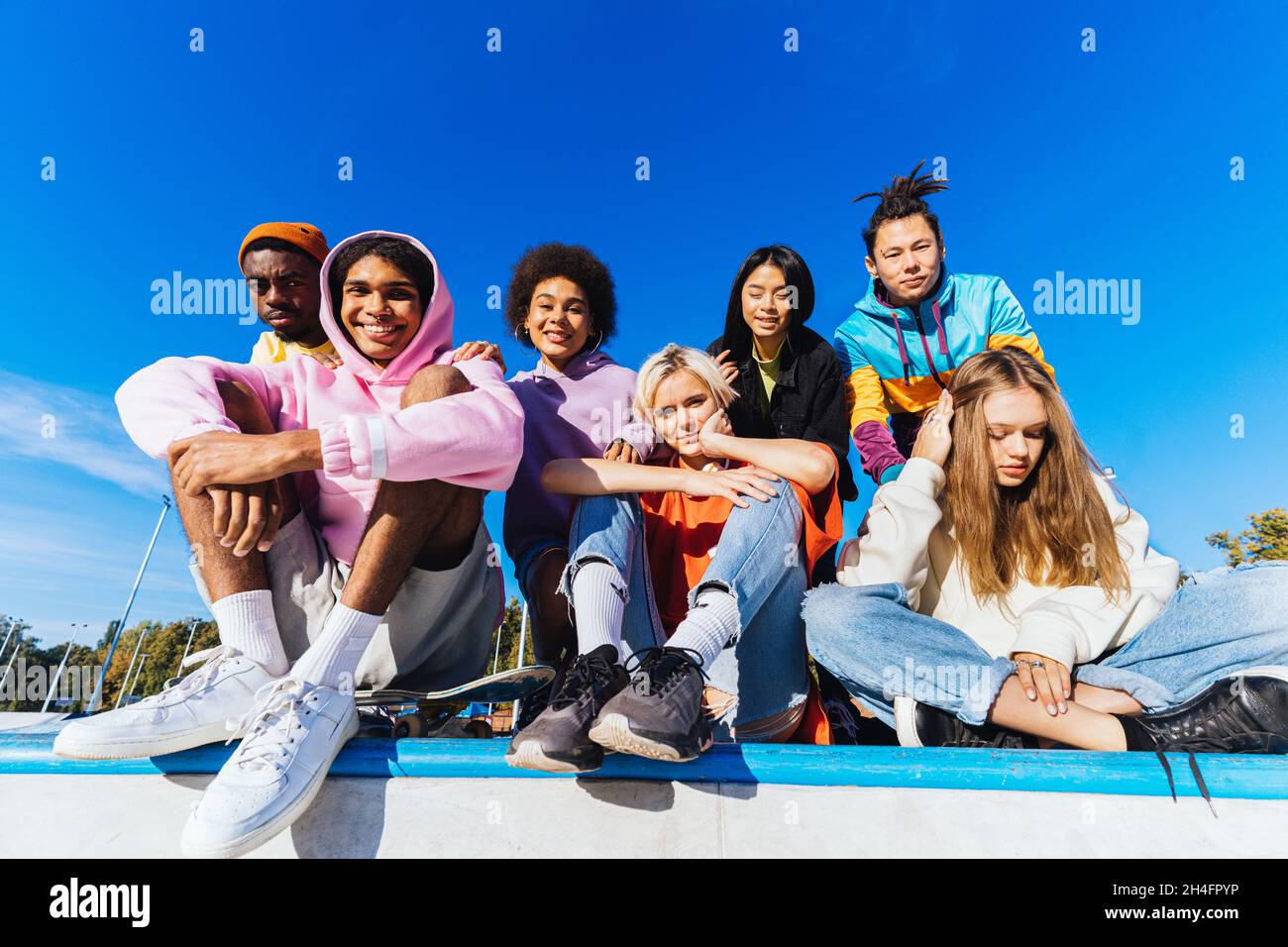 Groupe multiculturel de jeunes amis se liant à l'extérieur et s'amuser ...