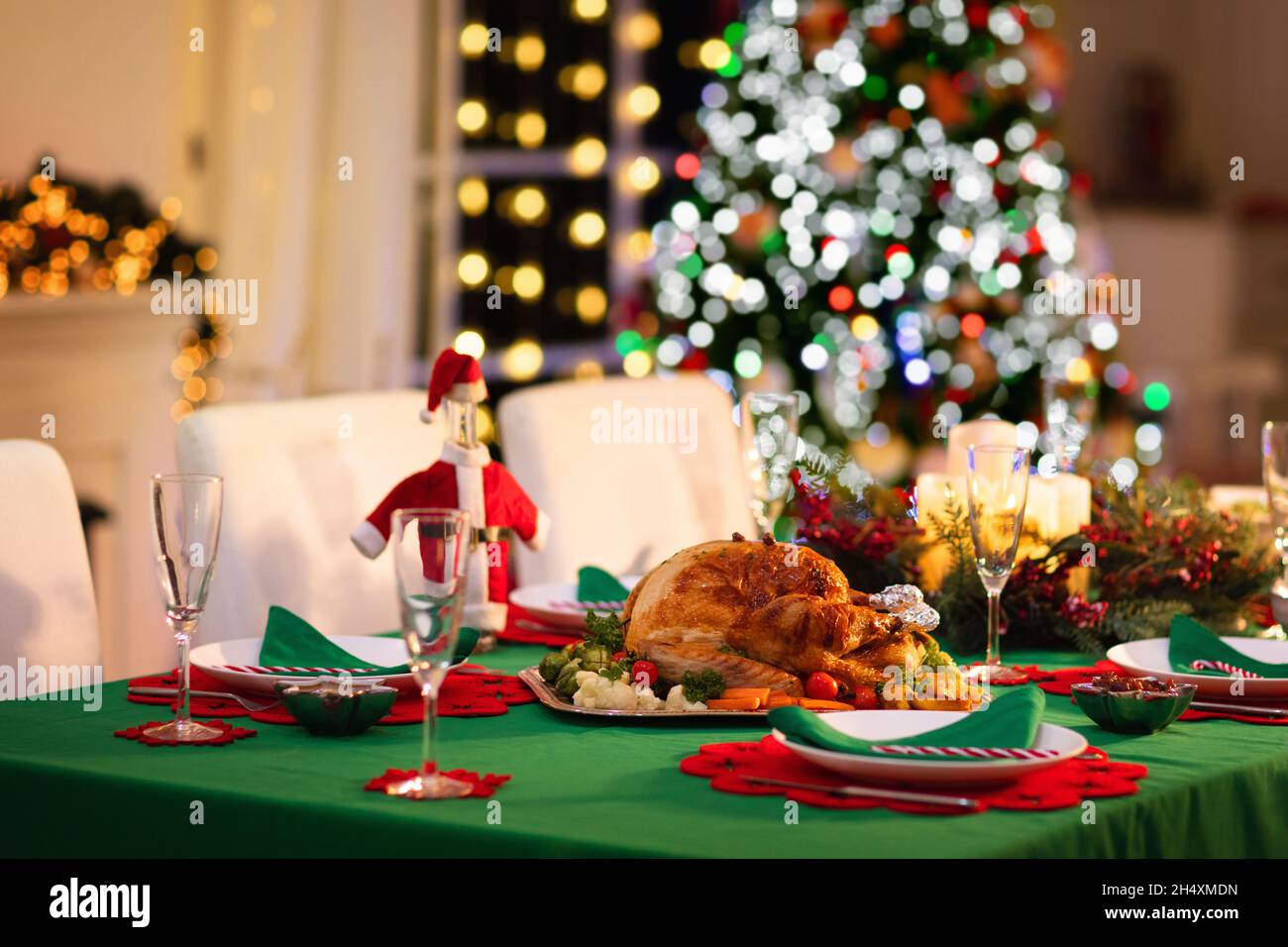 Dîner de Noël au foyer et arbre de Noël décoré. Plat avec dinde rôtie ...